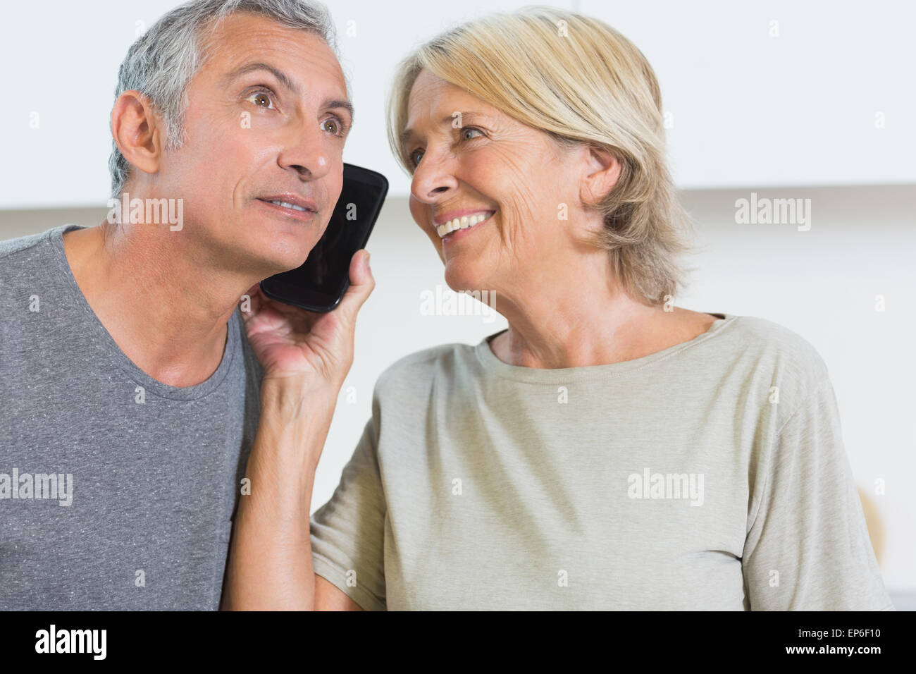 Happy mature couple listening a call together Stock Photo - Alamy