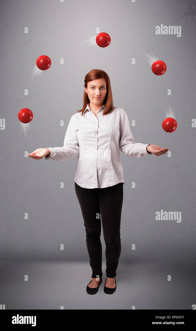 young girl standing and juggling with red balls Stock Photo - Alamy