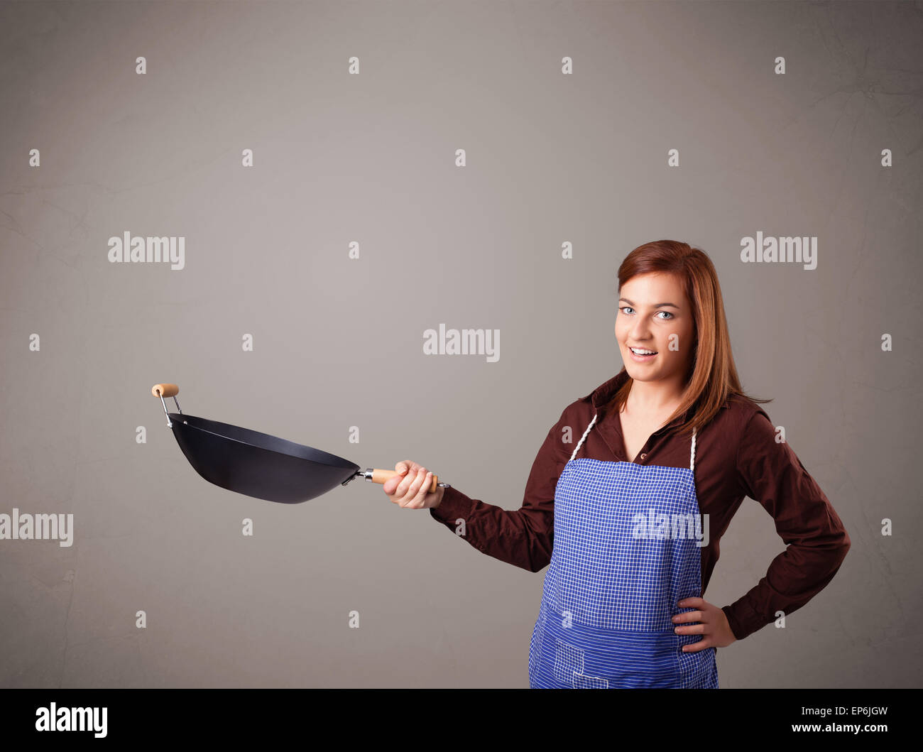 Young lady holding a frying pan Stock Photo - Alamy