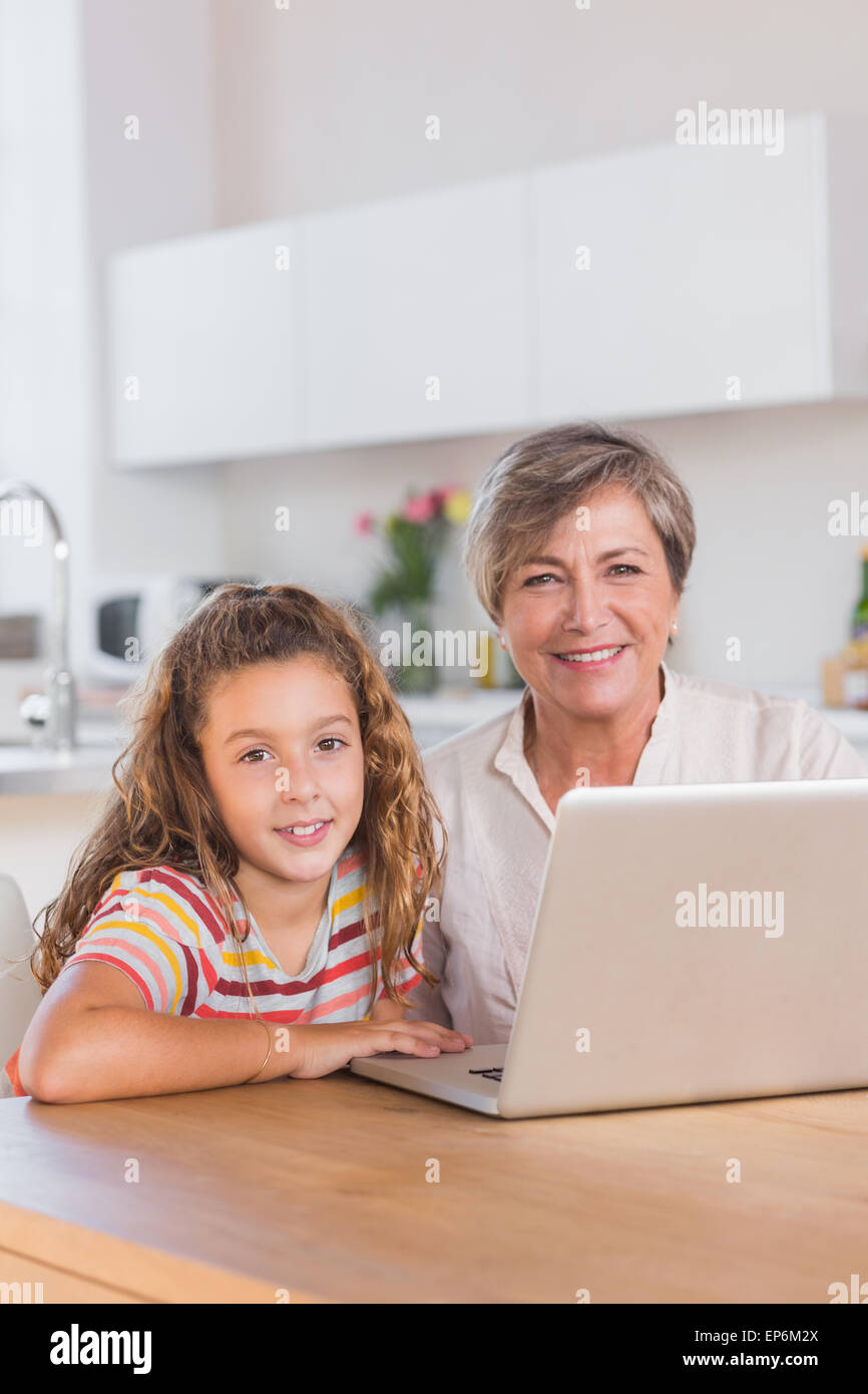 Smiling child and granny looking at the camera with laptop Stock Photo ...