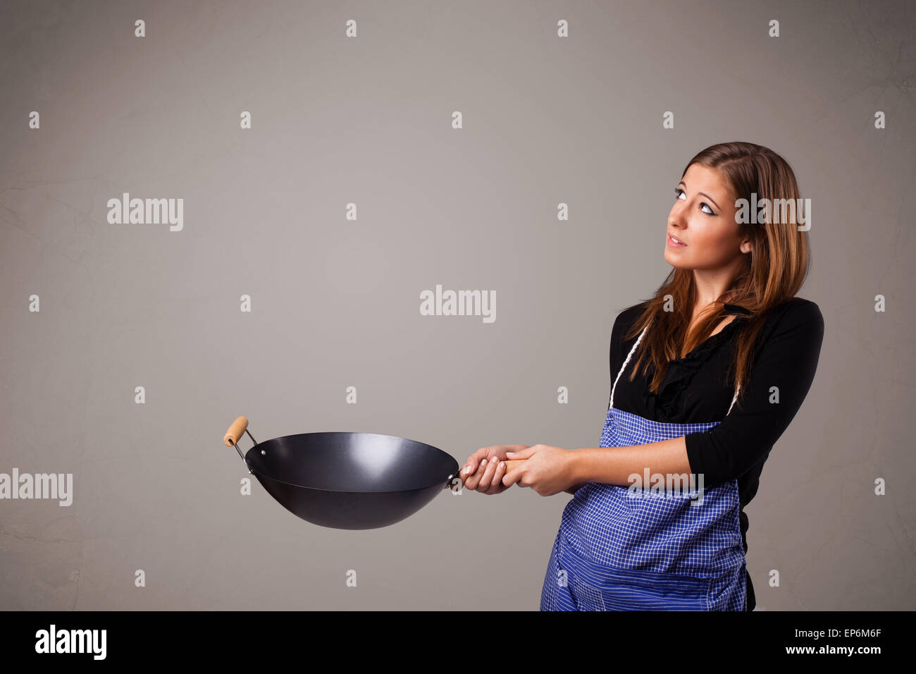 Young lady holding a frying pan Stock Photo - Alamy