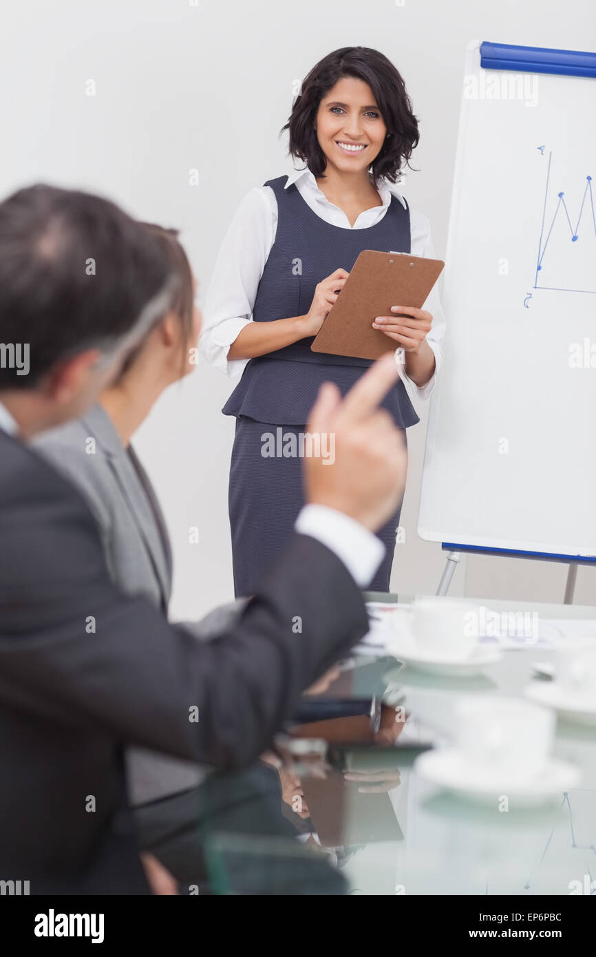 Man posing a question to his businesswoman with clipboard Stock Photo ...