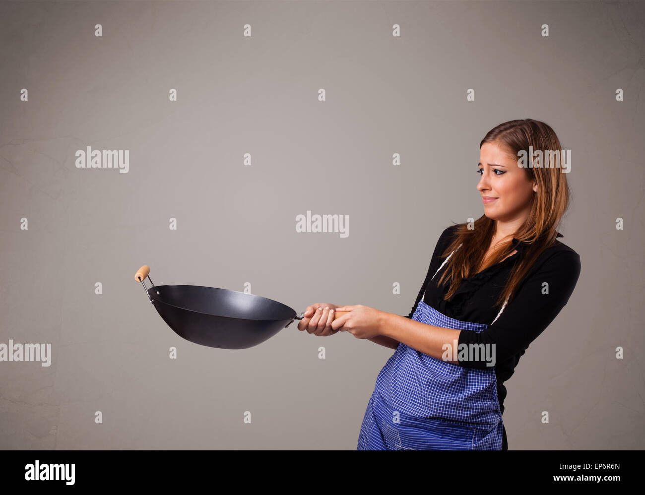Young lady holding a frying pan Stock Photo - Alamy