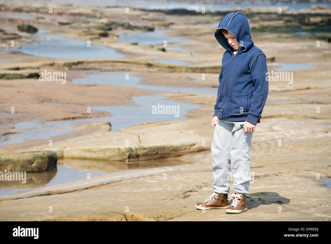 Boy standing on rocks Stock Photo - Alamy