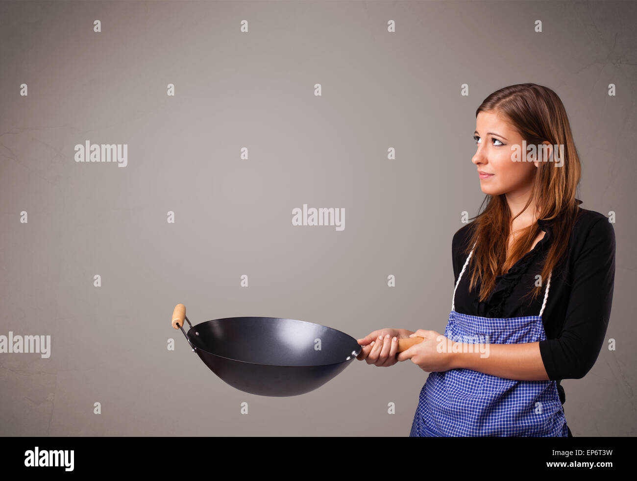 Young lady holding a frying pan Stock Photo - Alamy