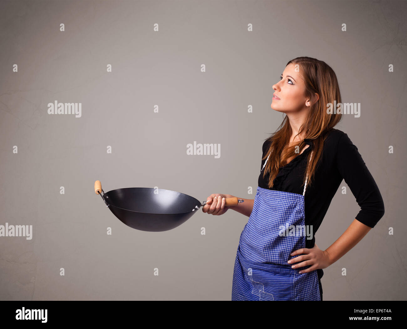 Young lady holding a frying pan Stock Photo - Alamy