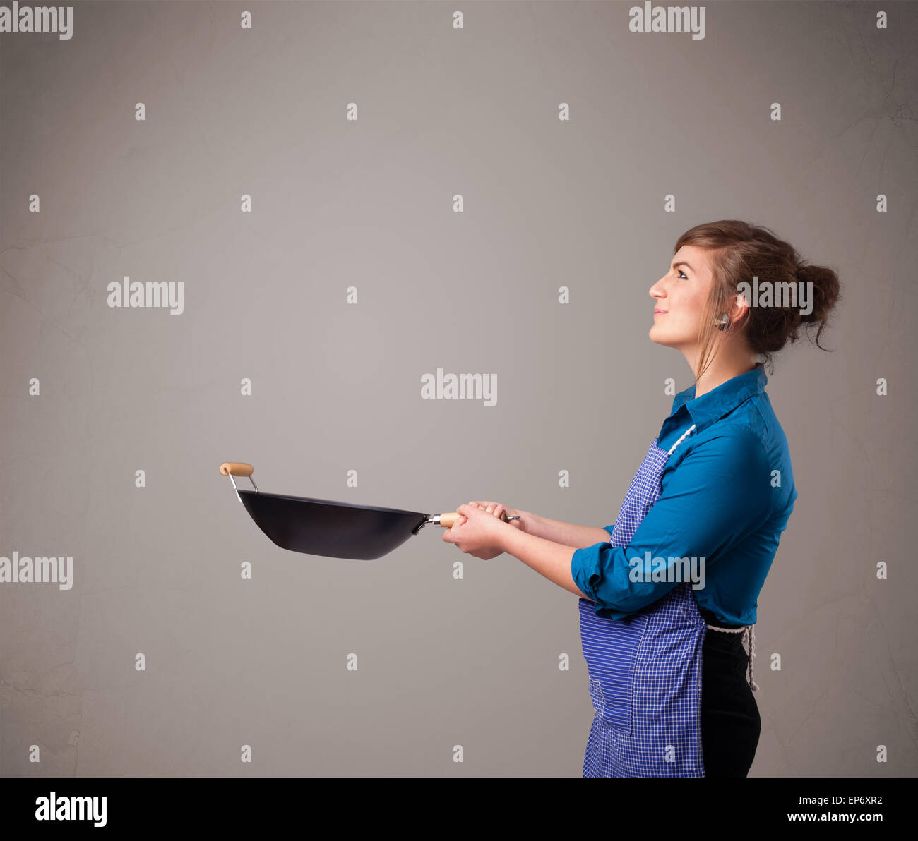 Young lady holding a frying pan Stock Photo - Alamy