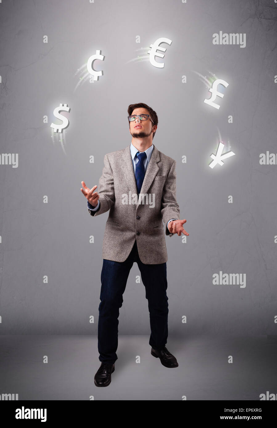 young man standing and juggling with currency icons Stock Photo - Alamy