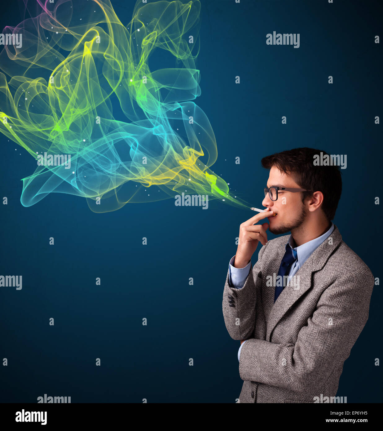 Handsome man smoking cigarette with colorful smoke Stock Photo - Alamy