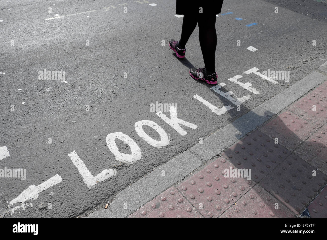 Pedestrian and LOOK LEFT sign on junction of road and pavement in ...