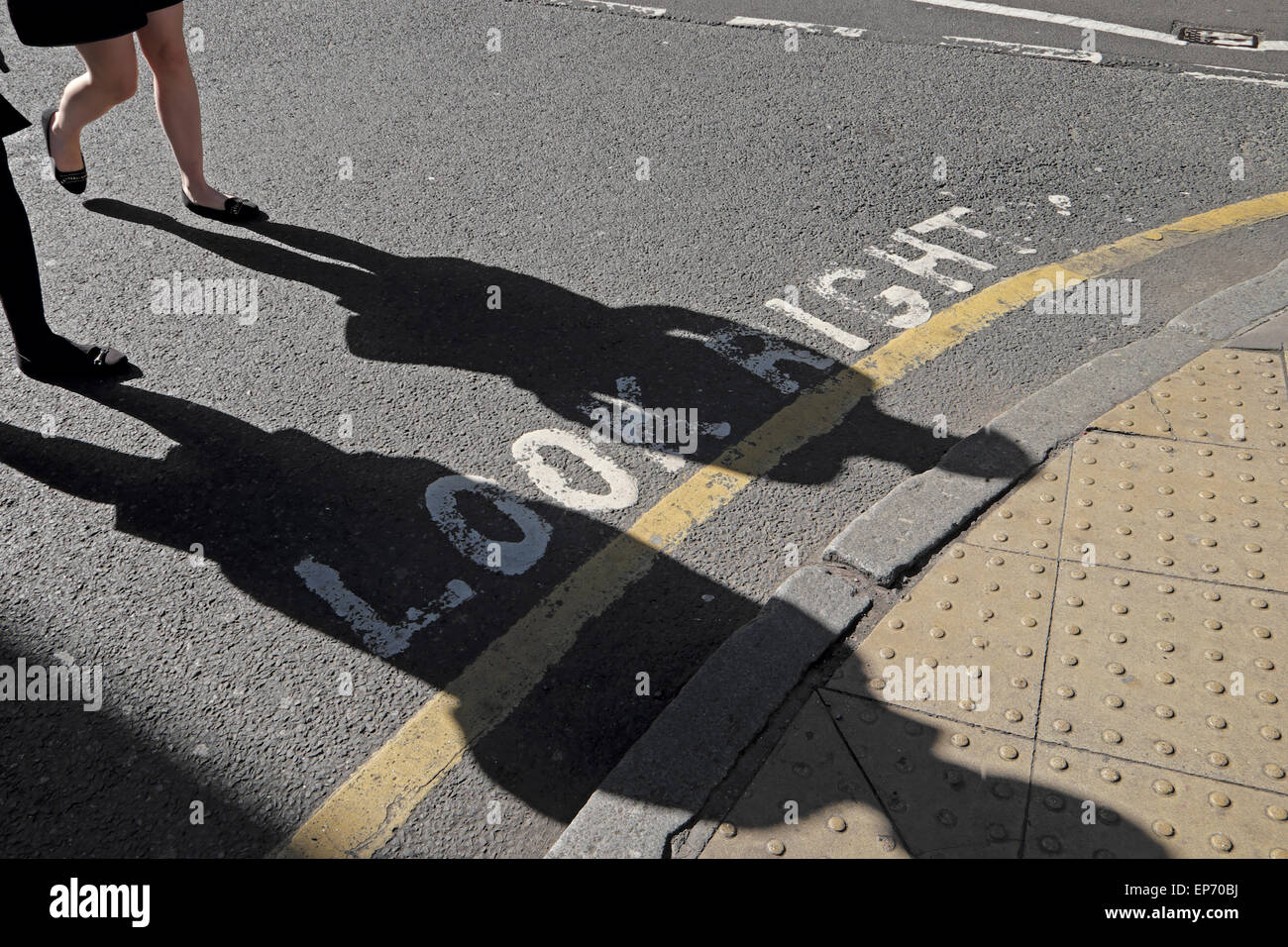 Pedestrian shadows and LOOK RIGHT sign on junction of road and pavement ...