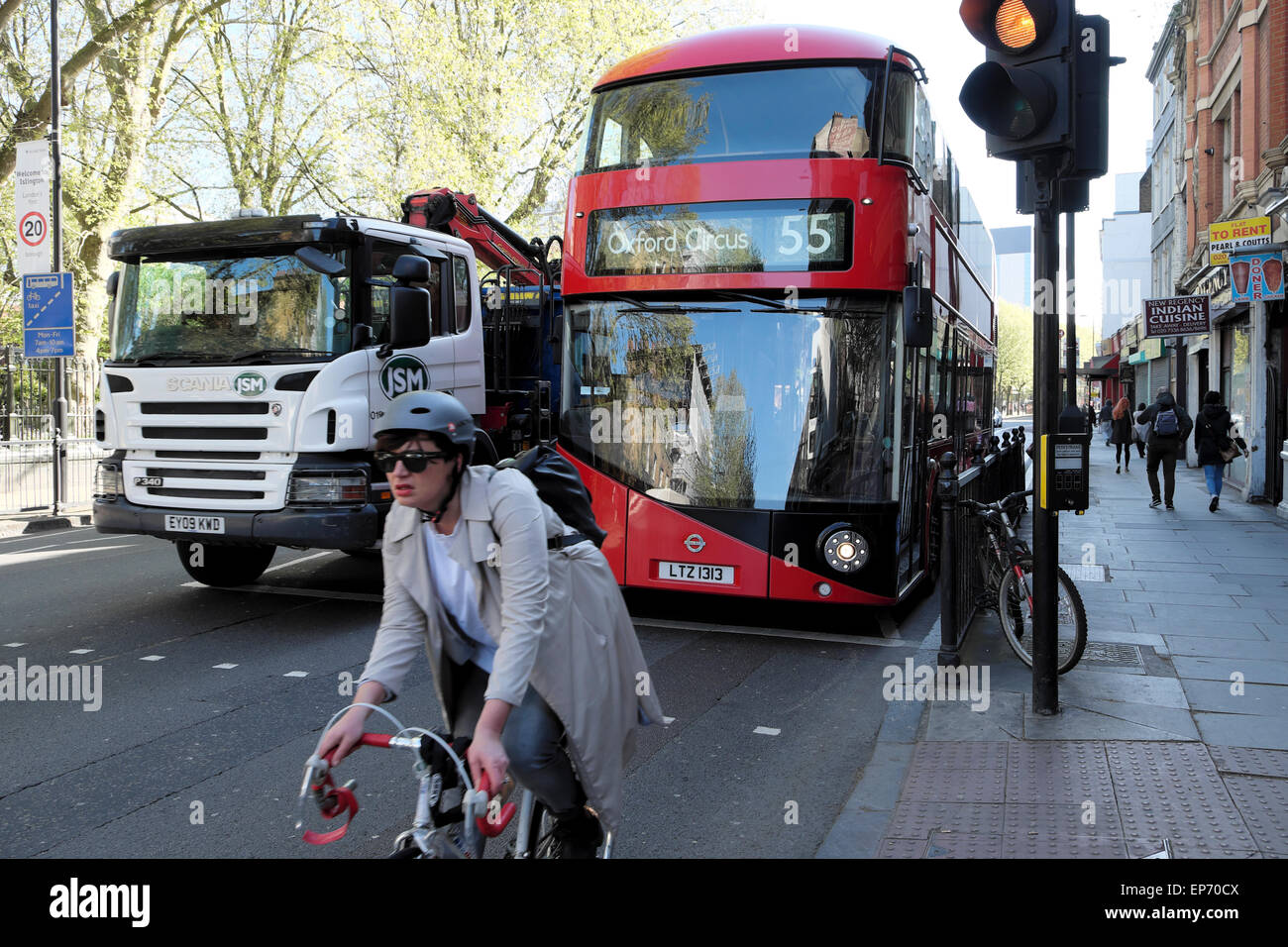 A female cyclist riding a racing bike through traffic lights ahead of a ...
