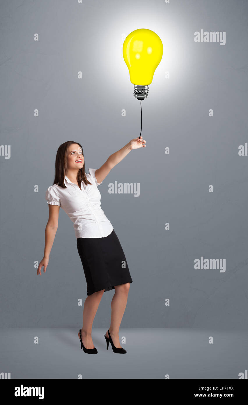 Pretty lady holding a light bulb balloon Stock Photo - Alamy