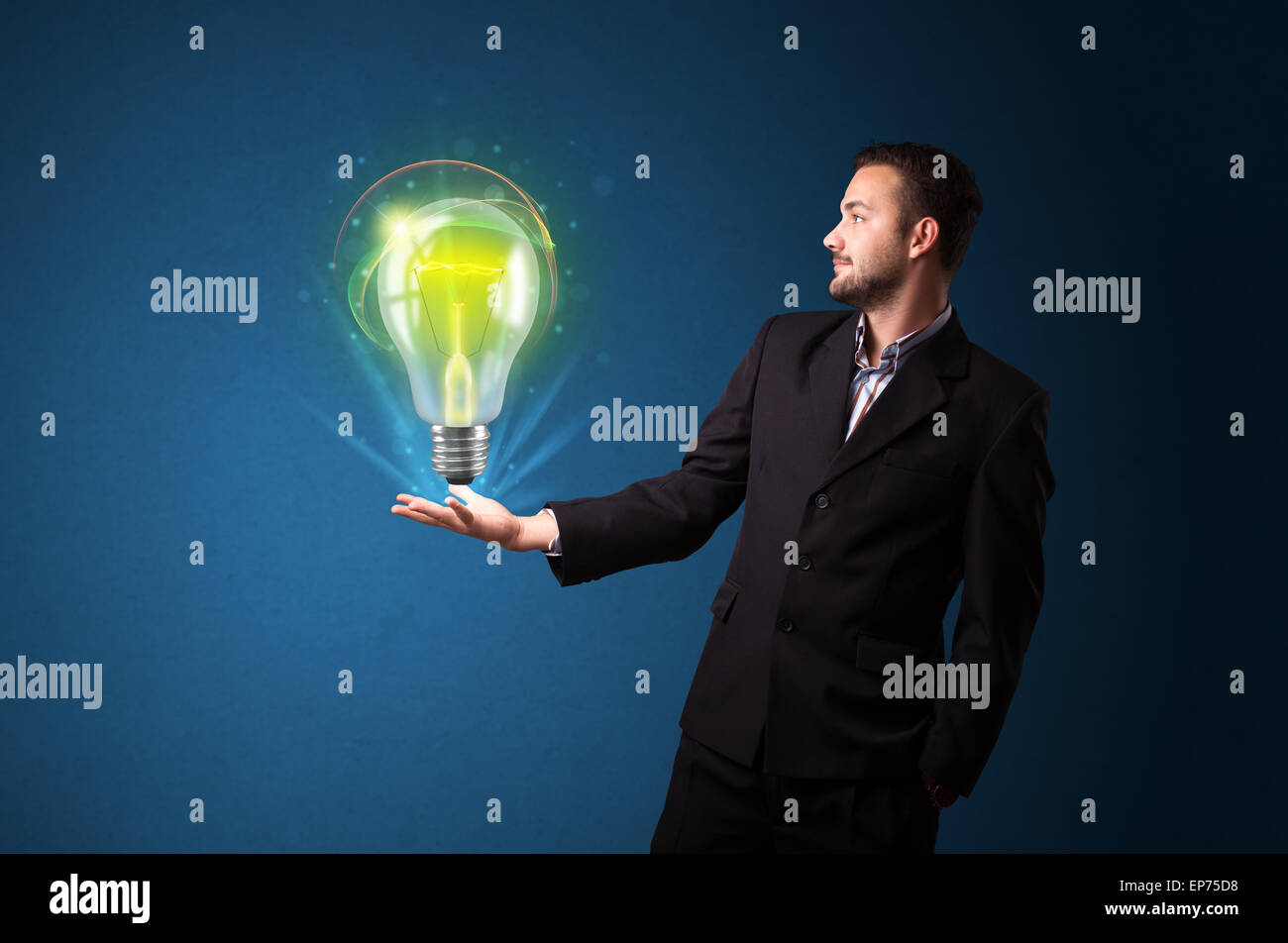 Glowing lightbulb in the hand of a businessman Stock Photo - Alamy
