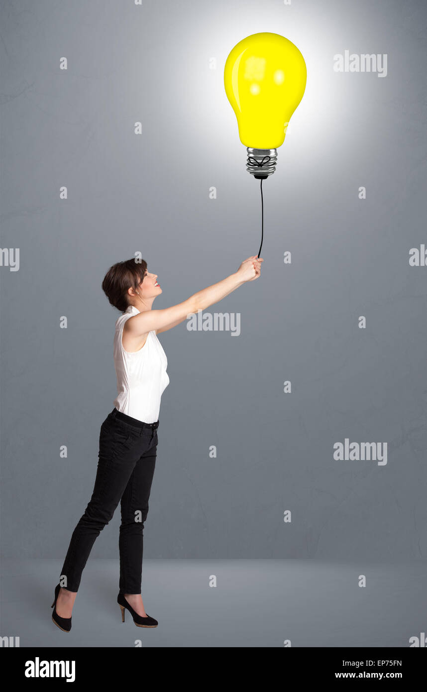 Pretty lady holding a light bulb balloon Stock Photo - Alamy