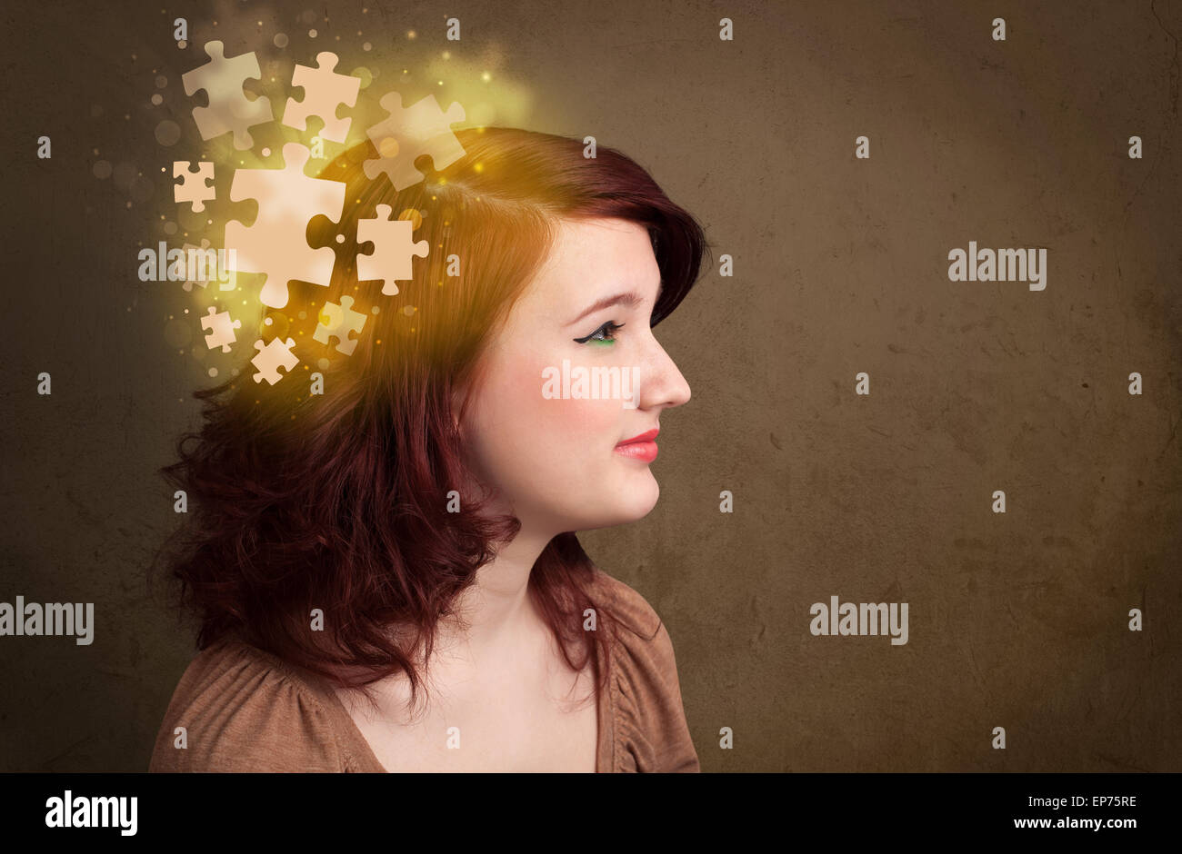 Young person thinking with glowing puzzle mind Stock Photo - Alamy