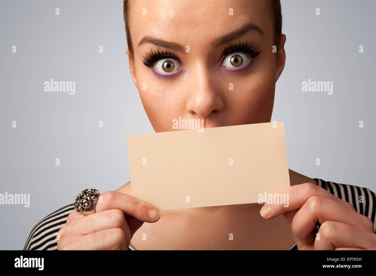 Cute girl holding white card at front of her lips with copy space Stock ...