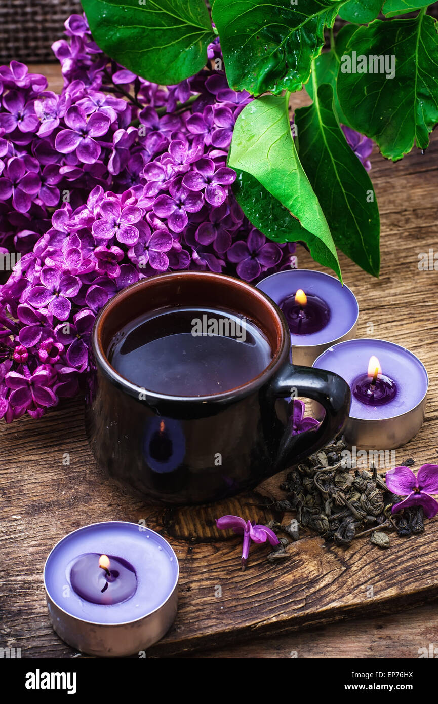 fragrant spring flower tea on the background of burning candles and ...