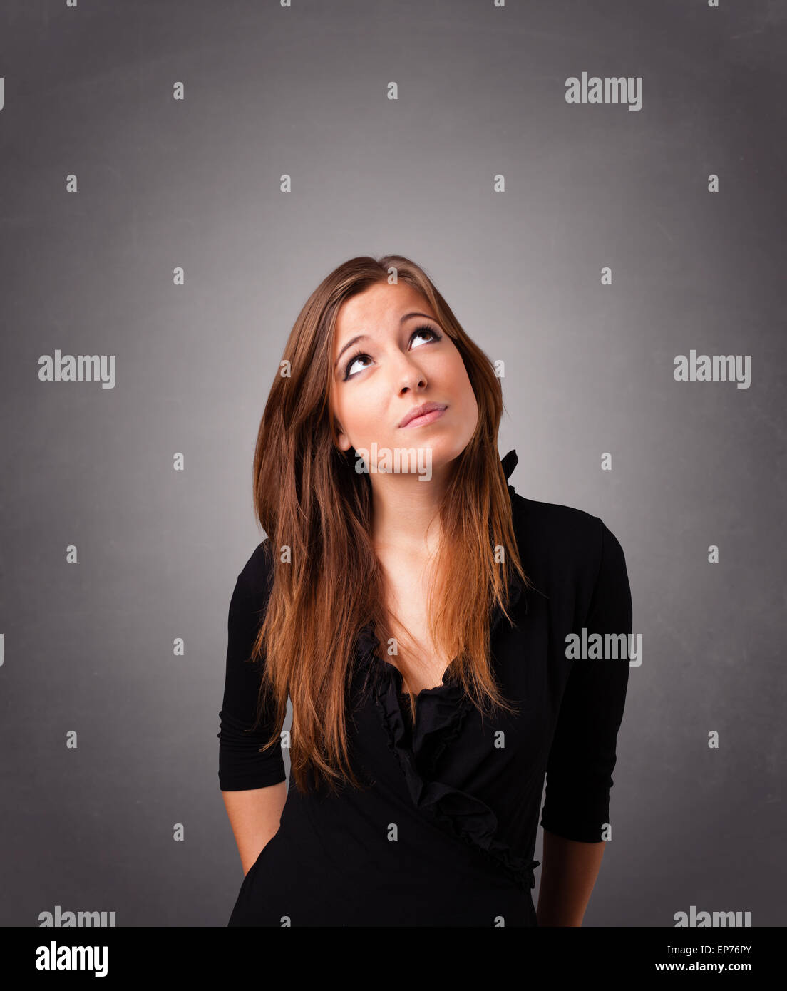 Young woman standing and thinking with copy space Stock Photo - Alamy