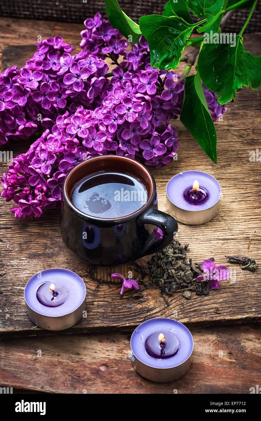 fragrant spring flower tea on the background of burning candles and ...