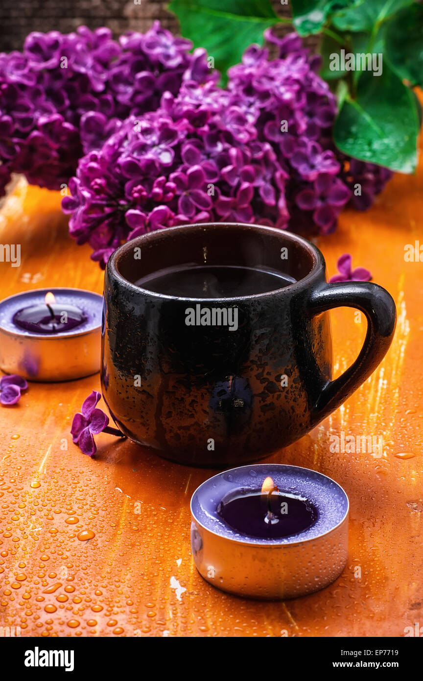 fragrant spring flower tea on the background of burning candles and ...