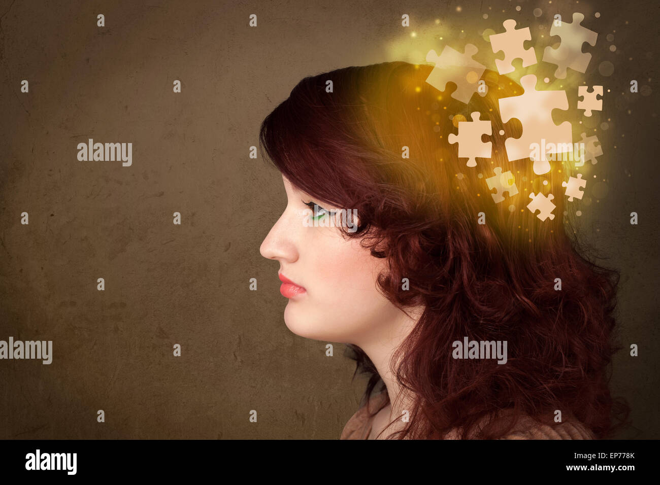 Young person thinking with glowing puzzle mind Stock Photo - Alamy