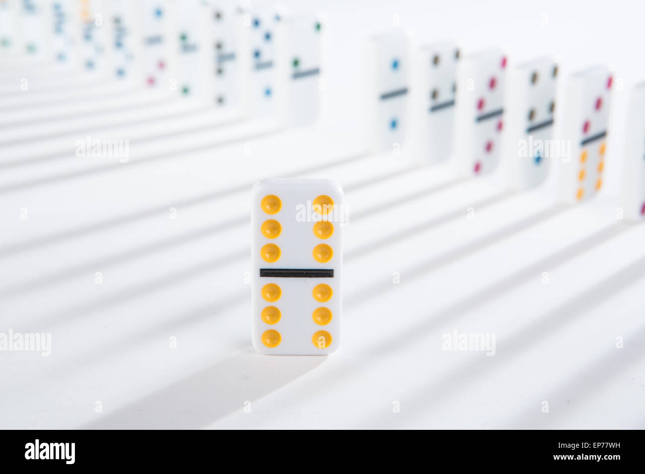 One yellow domino standing in front of line of dominoes Stock Photo - Alamy