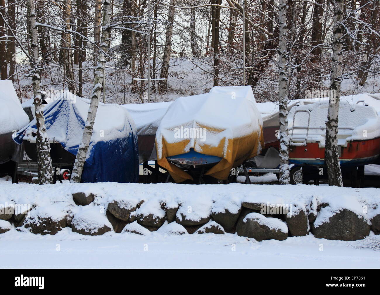Sailing boats packed for the winter with snow Stock Photo - Alamy