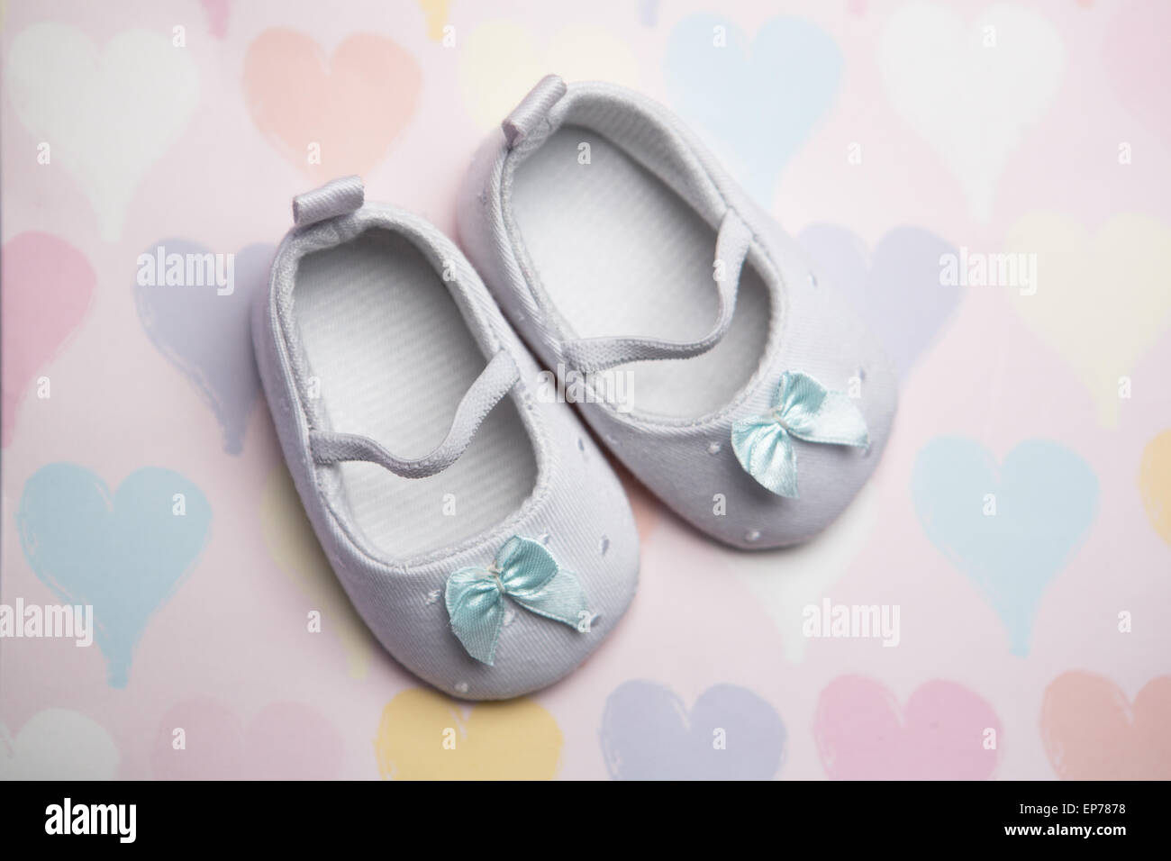 Baby blue booties on heart pattern background Stock Photo - Alamy