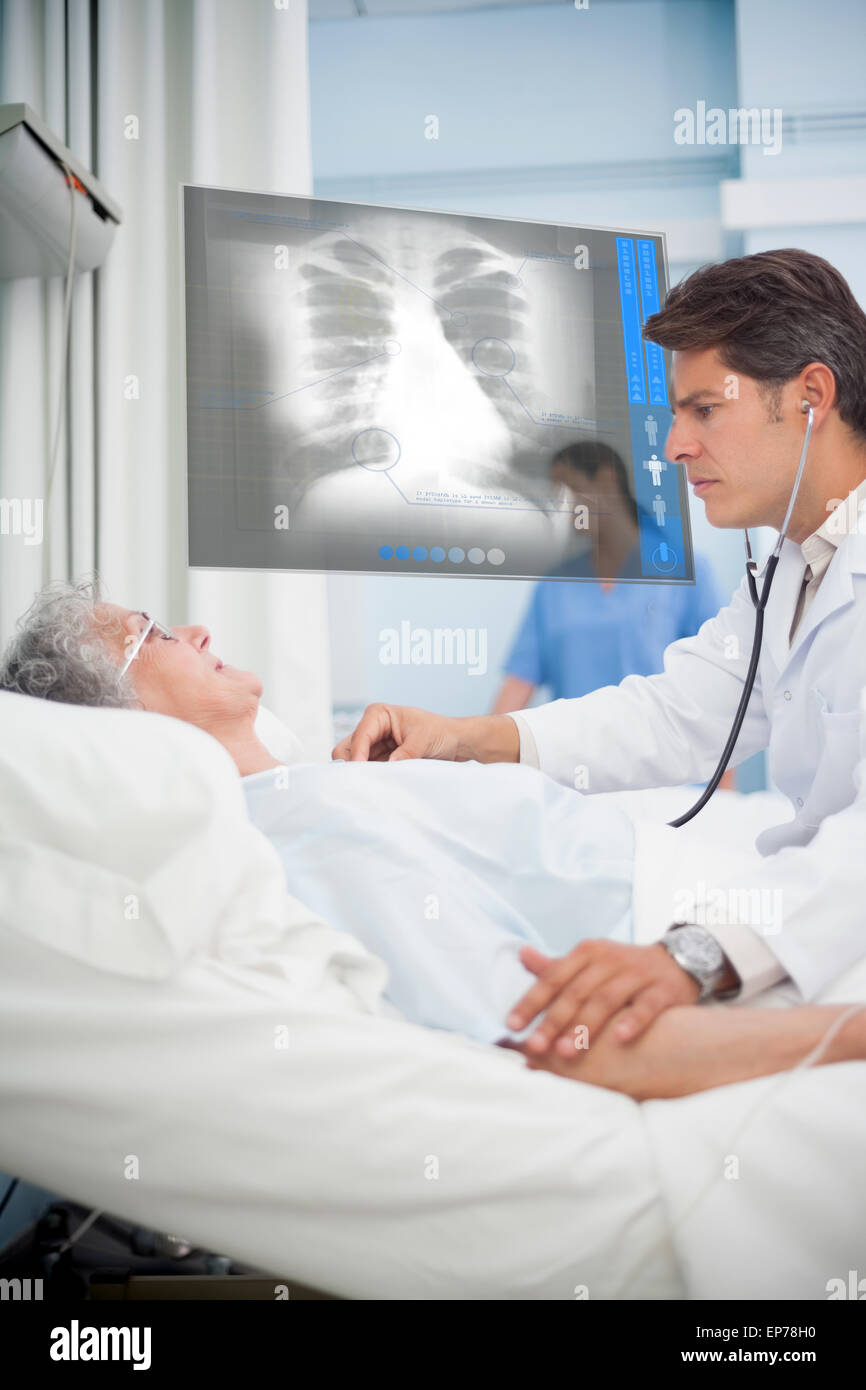Doctor checking pulse of elderly patient beside screen displaying chest ...