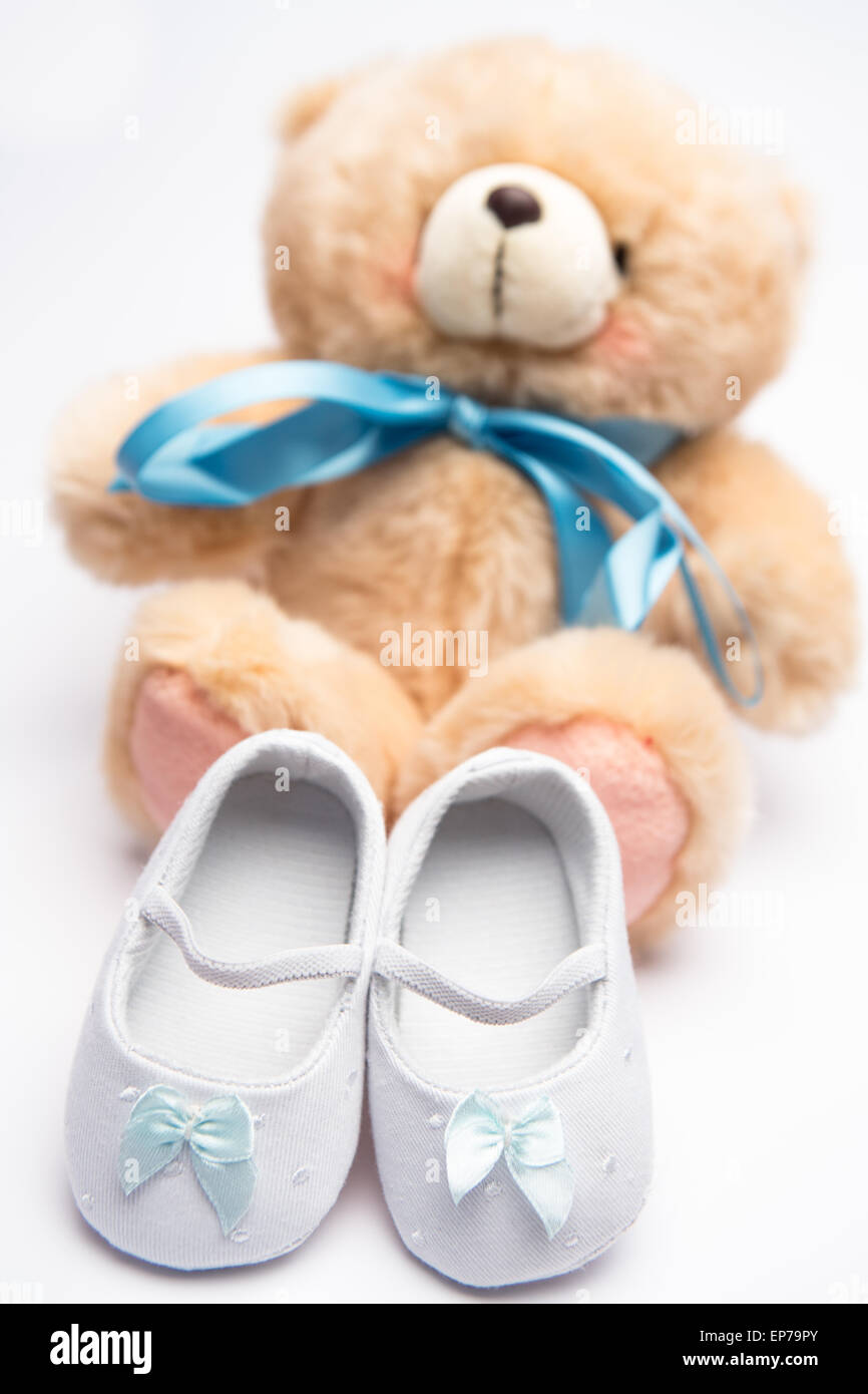 Teddy bear with blue ribbon and white booties Stock Photo - Alamy