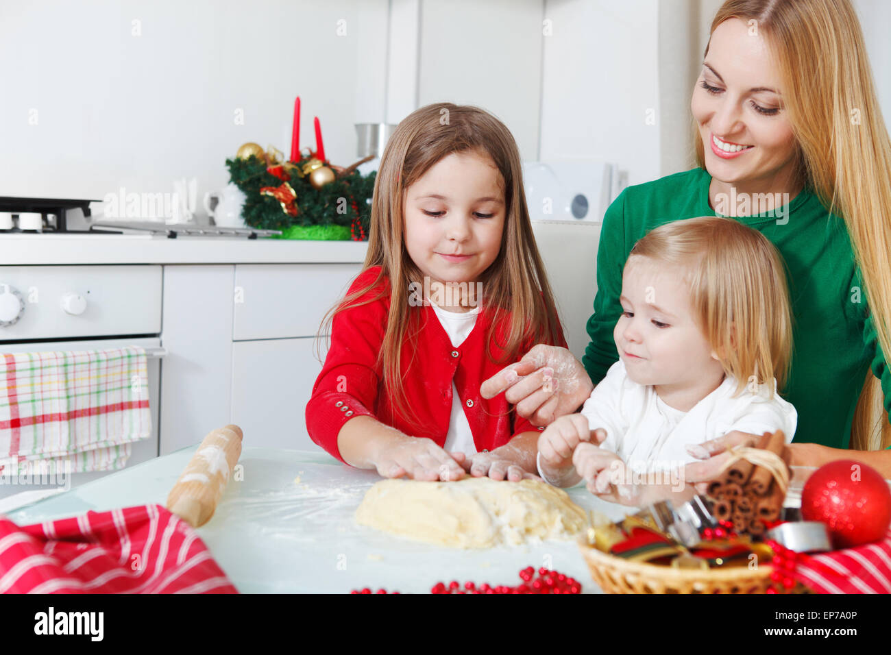 Two adorable girls with her mother baking Christmas cookies Stock Photo ...
