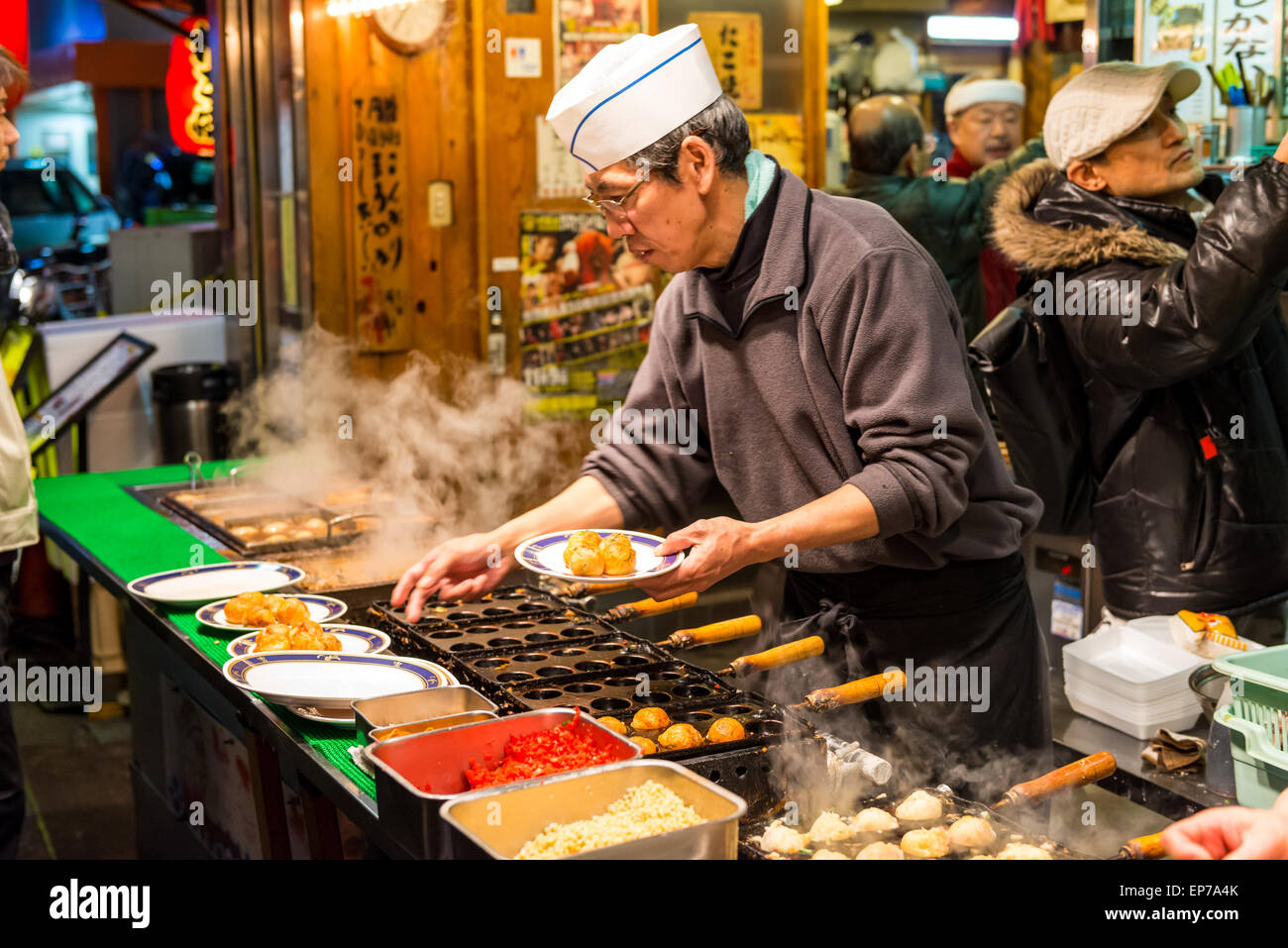 Japanese chefs prepare takoyaki and other snack foods at a stall in ...