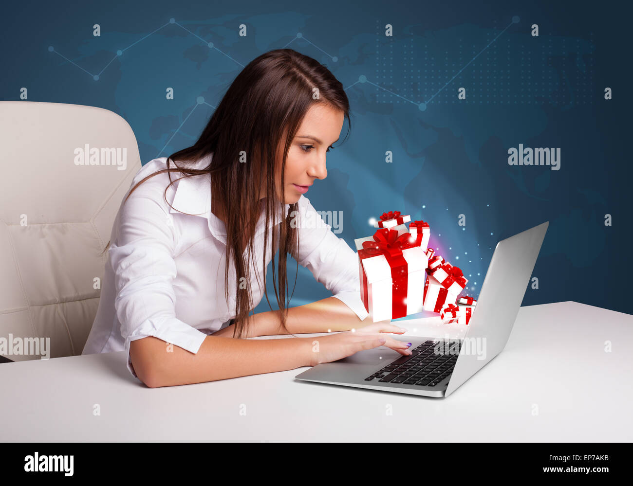 Pretty lady sitting at desk and typing on laptop with present boxes ...