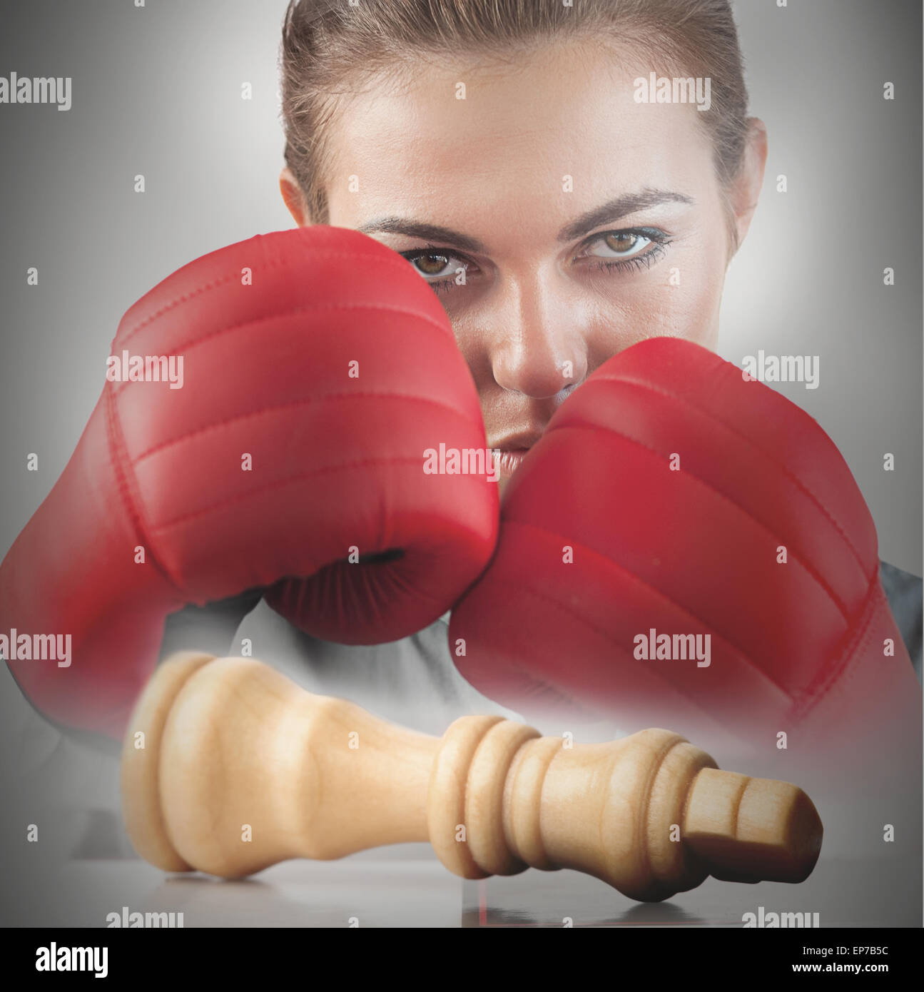Powerful female boxer with knocked chess piece Stock Photo - Alamy
