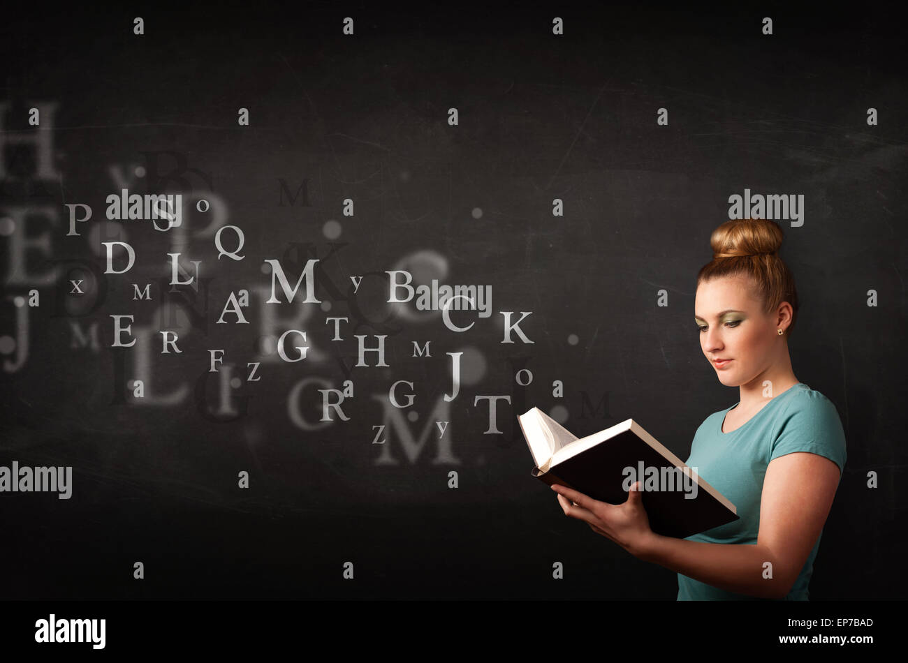 Young lady reading a book with alphabet letters Stock Photo - Alamy
