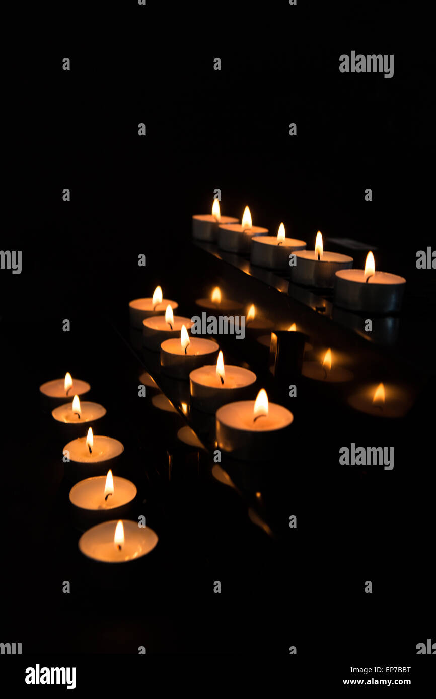 Candles at the alter lighting up the darkness Stock Photo - Alamy