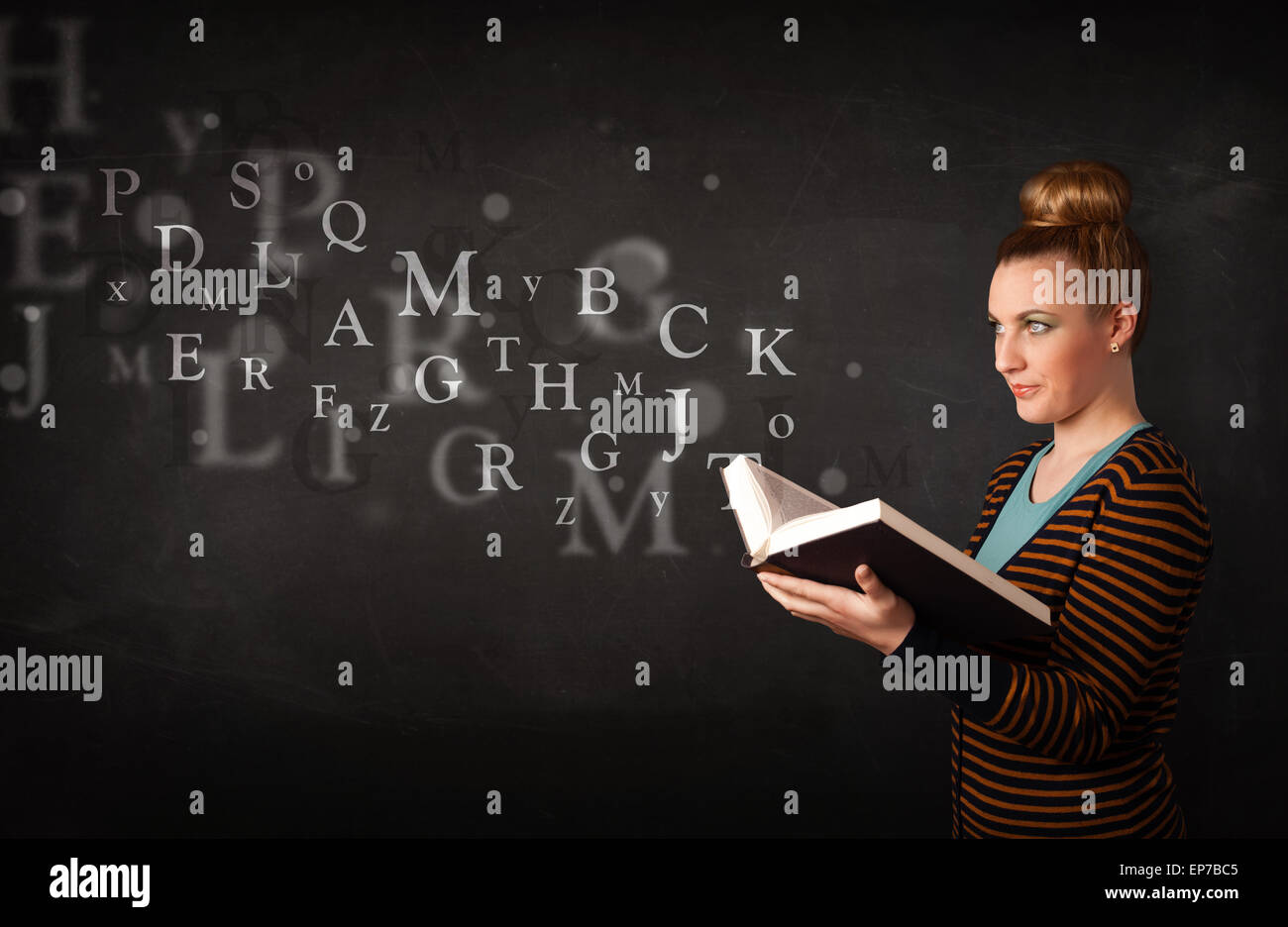 Young lady reading a book with alphabet letters Stock Photo - Alamy