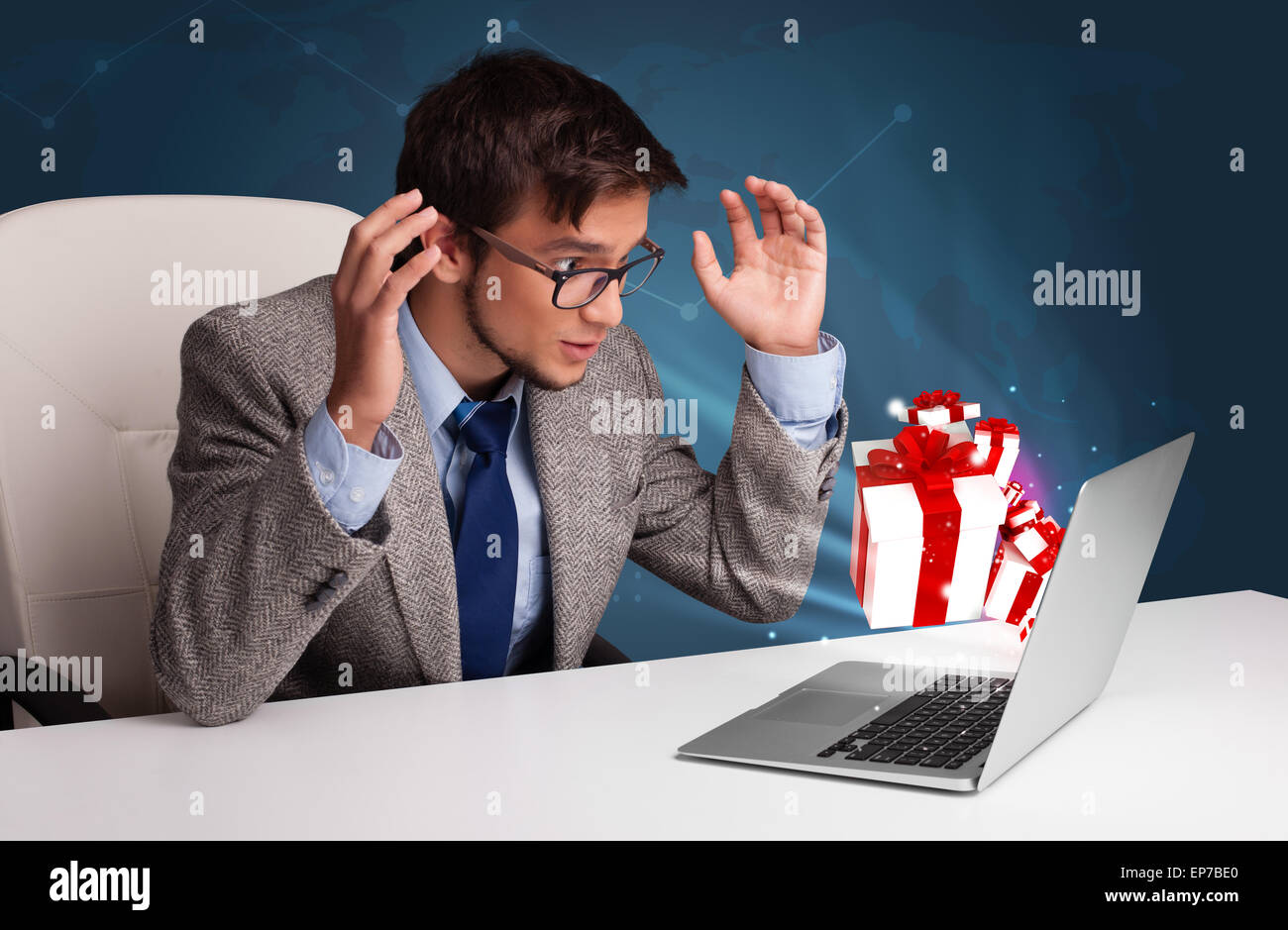 Angry man sitting at desk and typing on laptop with present boxes icons ...