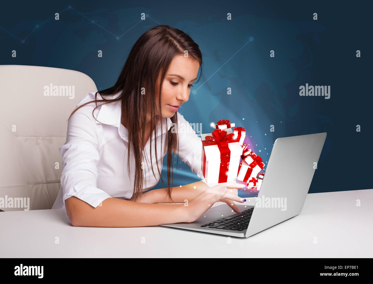 Pretty lady sitting at desk and typing on laptop with present boxes ...