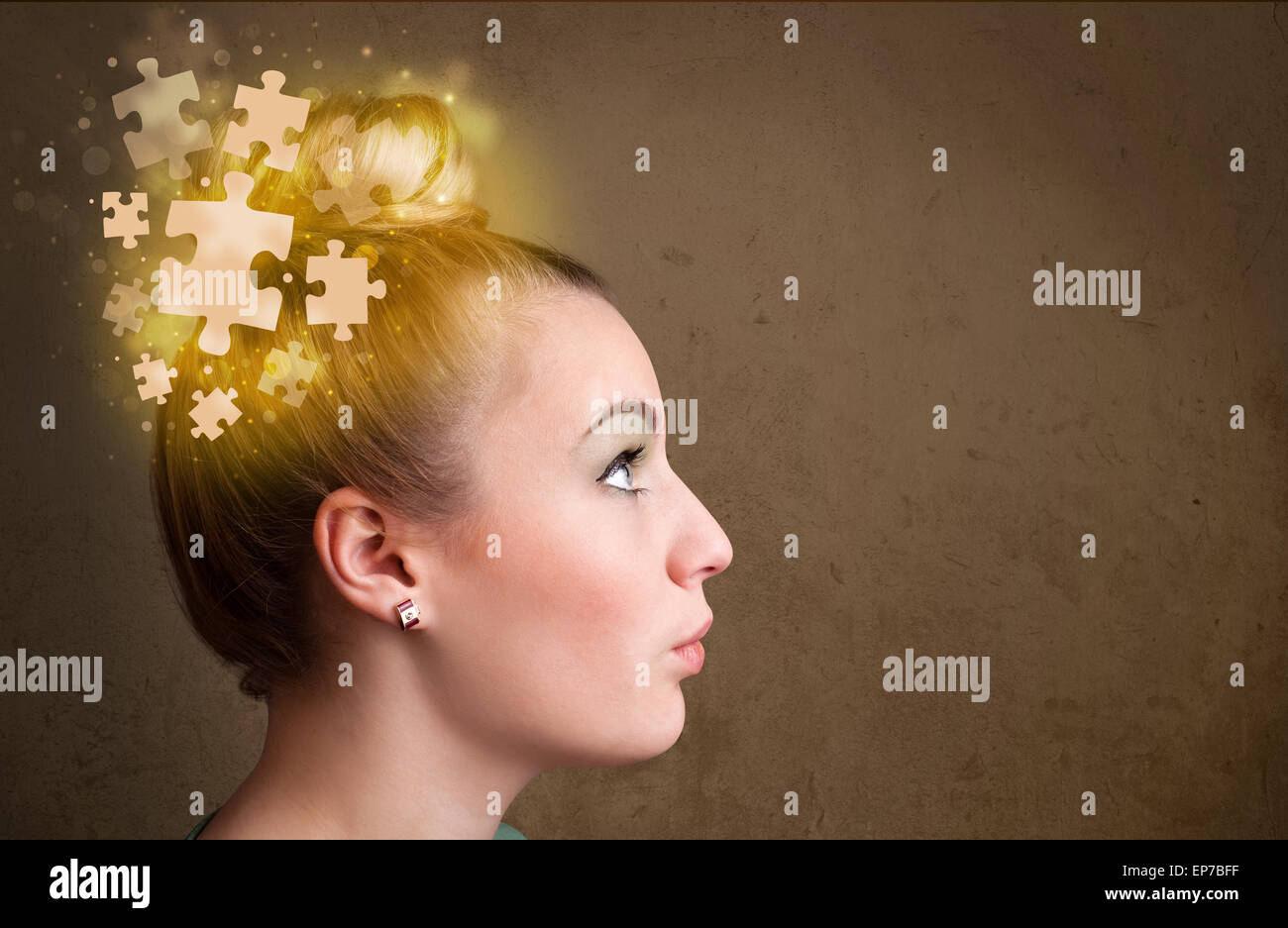 Young person thinking with glowing puzzle mind Stock Photo - Alamy