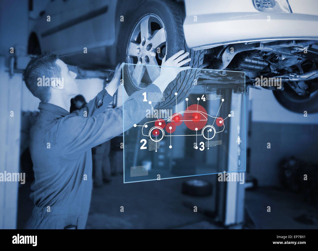 Mechanic checking wheel of a car while looking interface Stock Photo ...