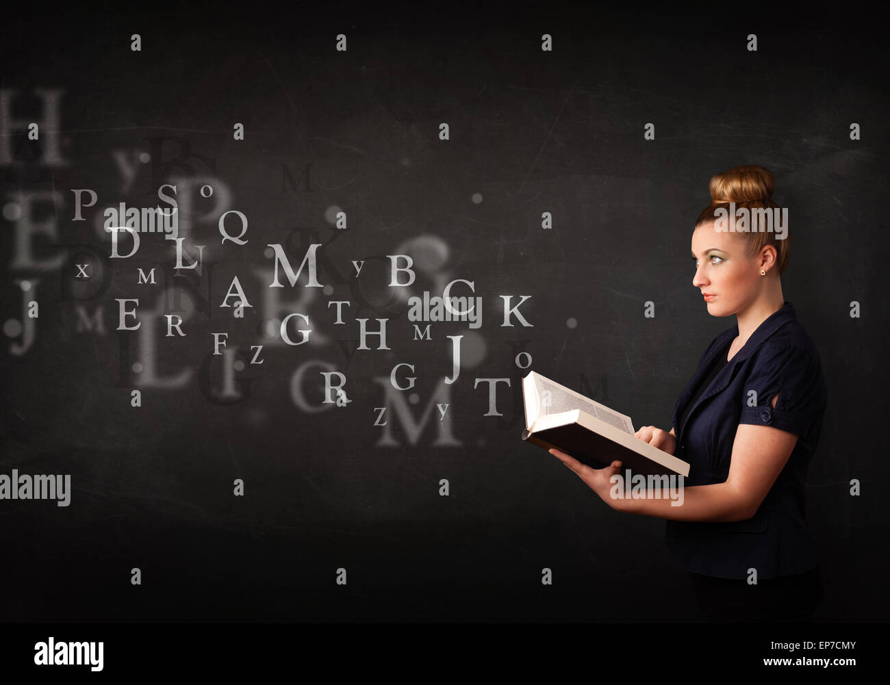 Young lady reading a book with alphabet letters Stock Photo - Alamy
