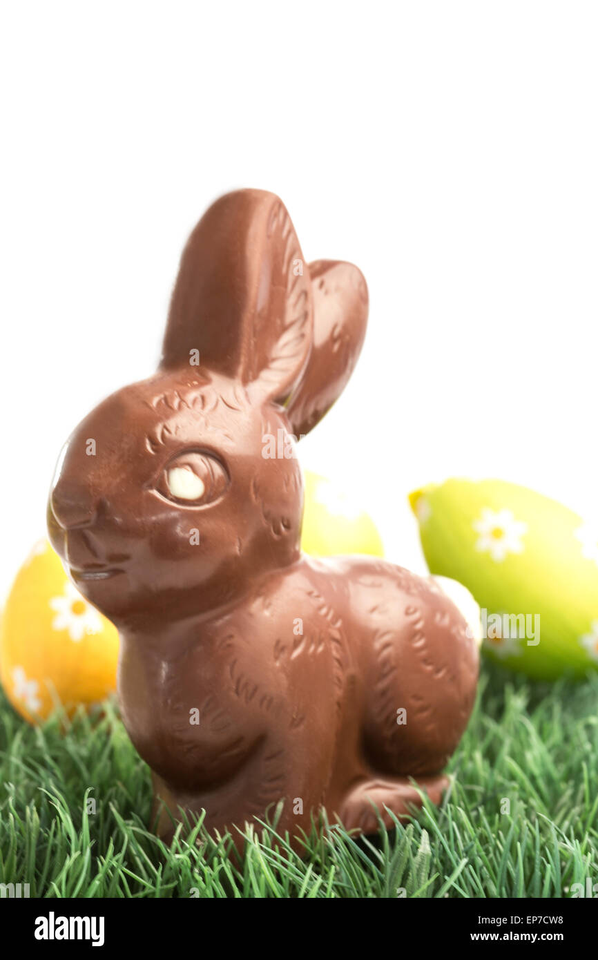 Chocolate bunny rabbit sitting on grass with easter eggs behind Stock ...