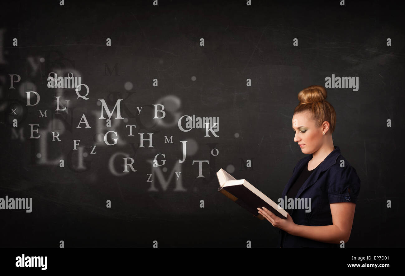 Young lady reading a book with alphabet letters Stock Photo - Alamy