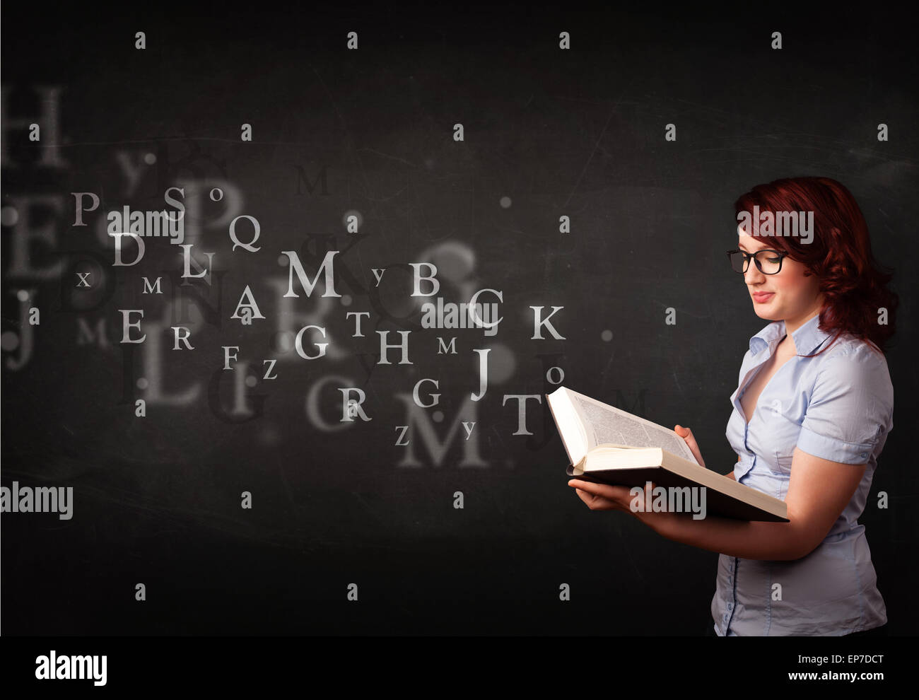 Young lady reading a book with alphabet letters Stock Photo - Alamy