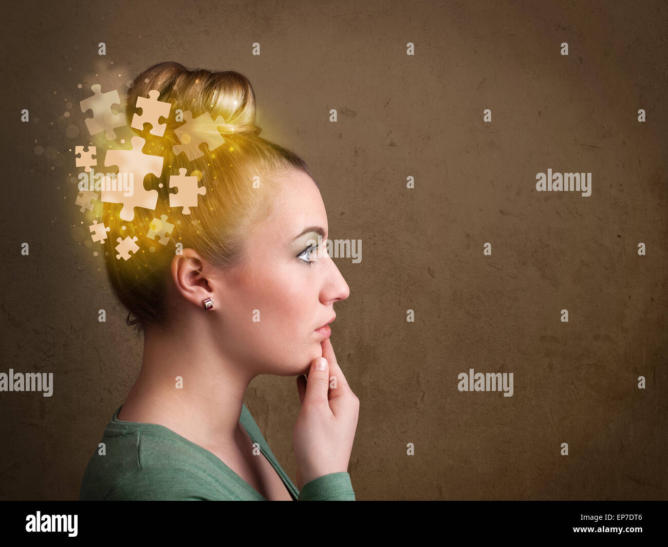 Young person thinking with glowing puzzle mind Stock Photo - Alamy