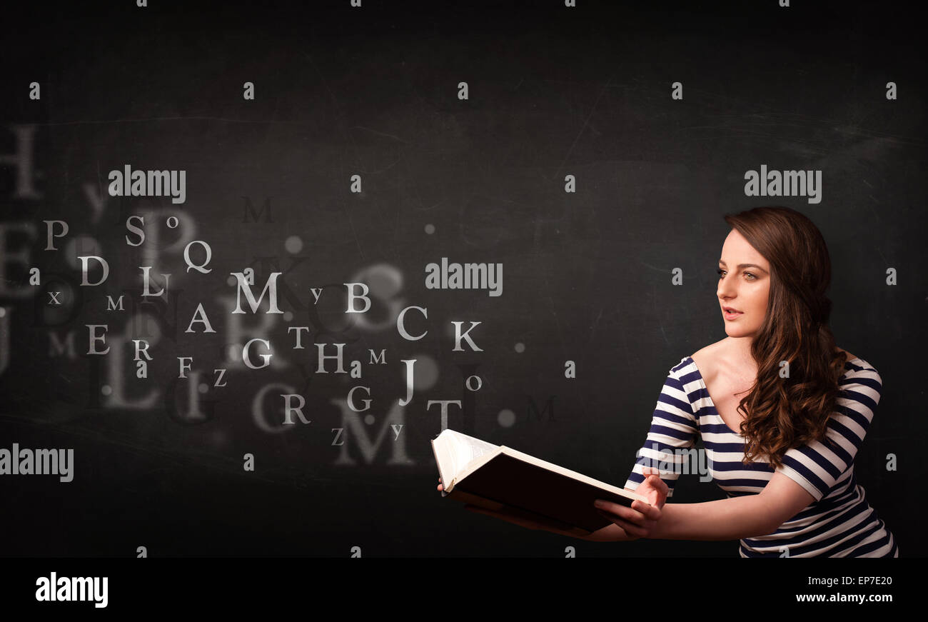 Young lady reading a book with alphabet letters Stock Photo - Alamy