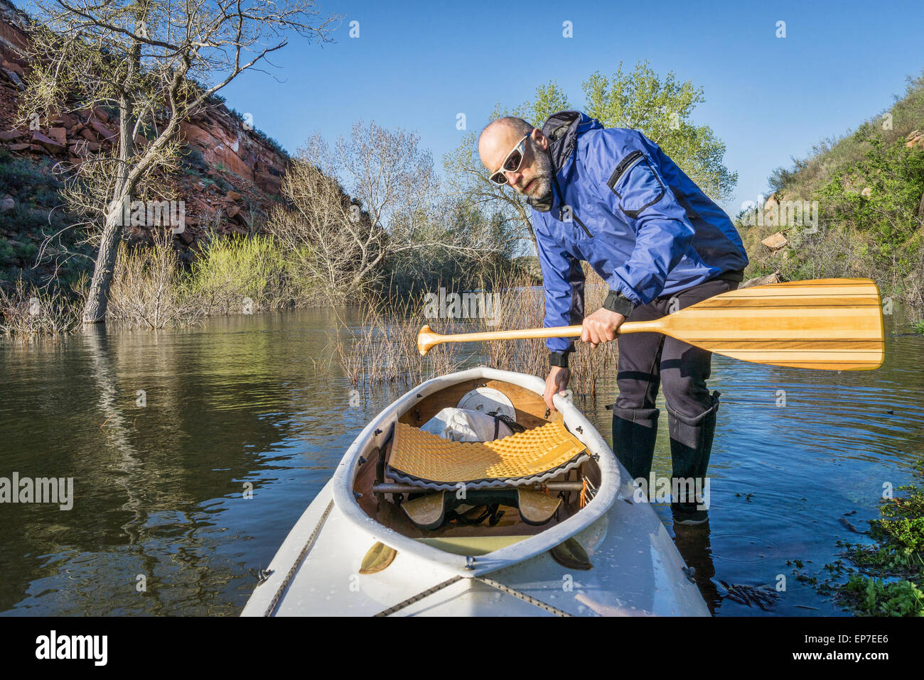 senior paddler and decked expedition canoe on the shore of Horsetooth ...