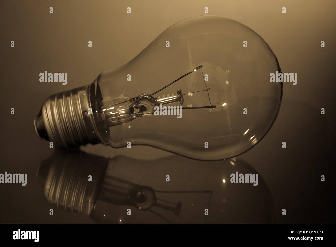 Clear light bulb laying on its side on reflective surface Stock Photo ...